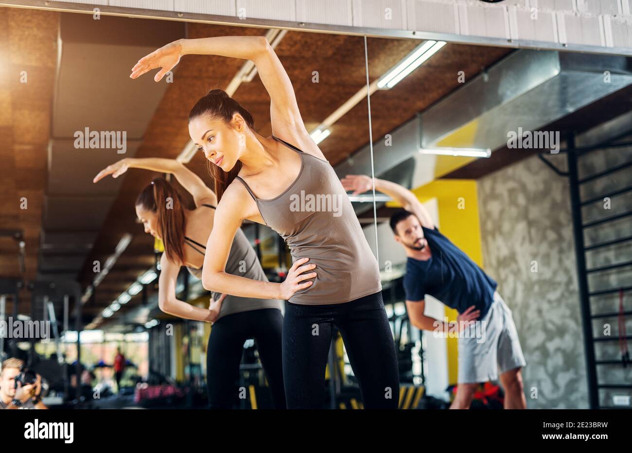 Group of young athletes stretching in gym before exercising Stock Photo ...