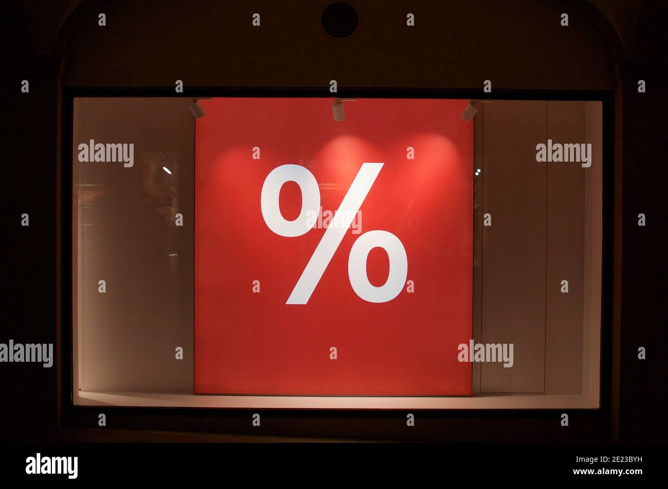 Illuminated red percent Sale sign inside a shop window in the city of ...