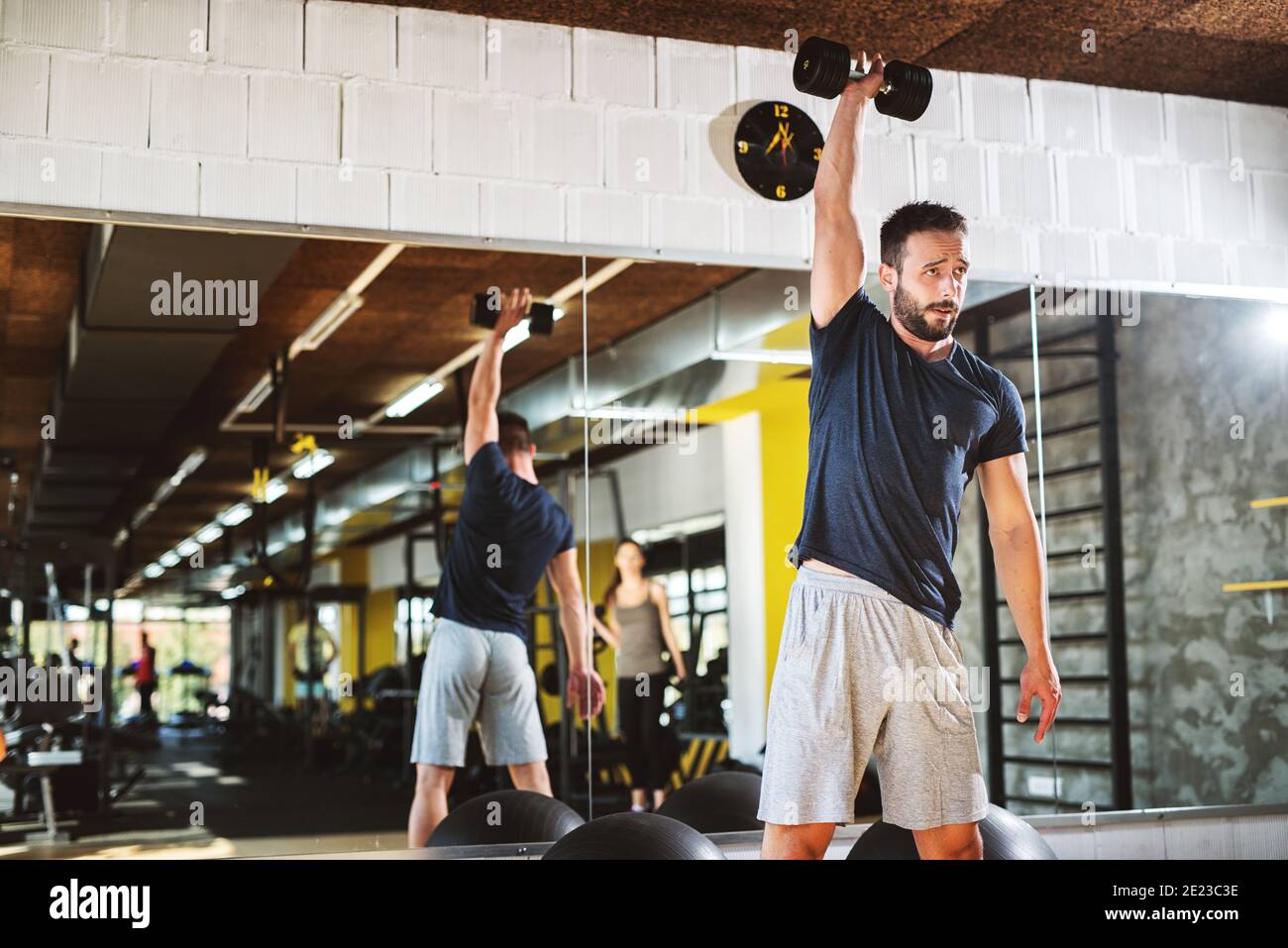 Young tired strong man lifting weights in a gym Stock Photo - Alamy