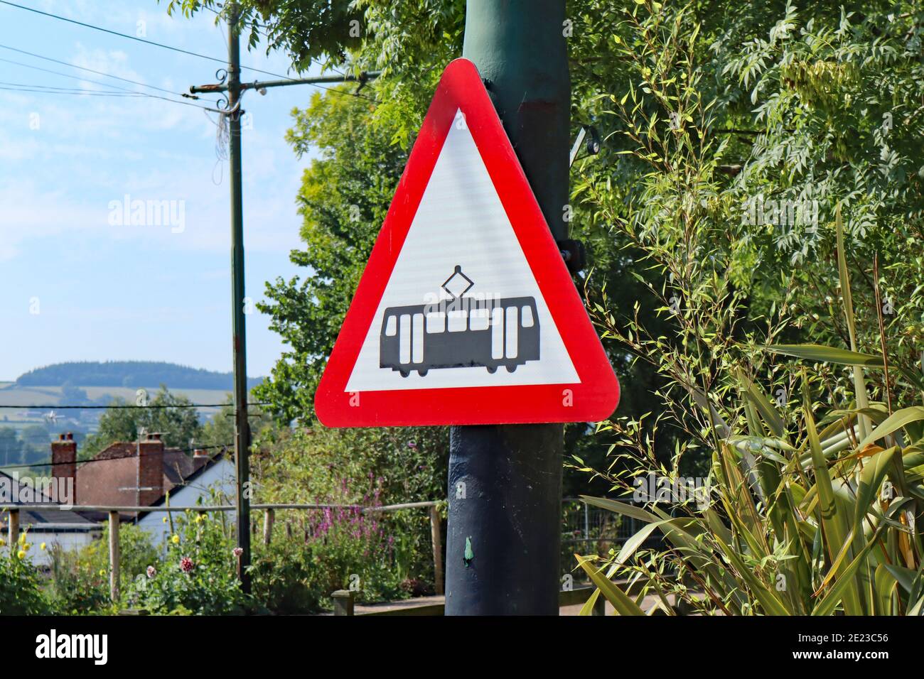 A red and white triangular warning sign of a tram crossing at Colyton ...