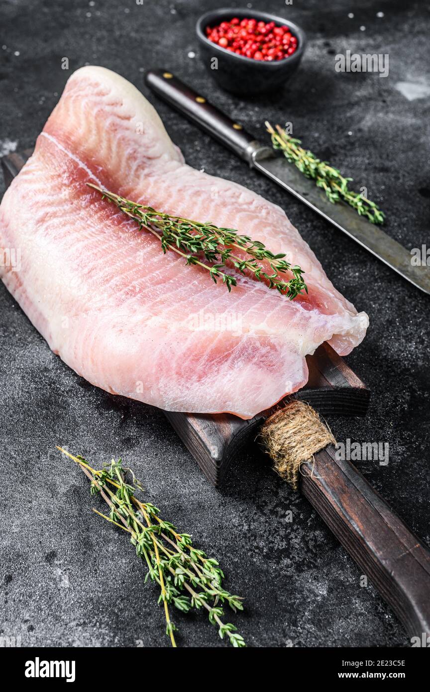 Fresh raw white fish fillet Pangasius with spices. Black background ...
