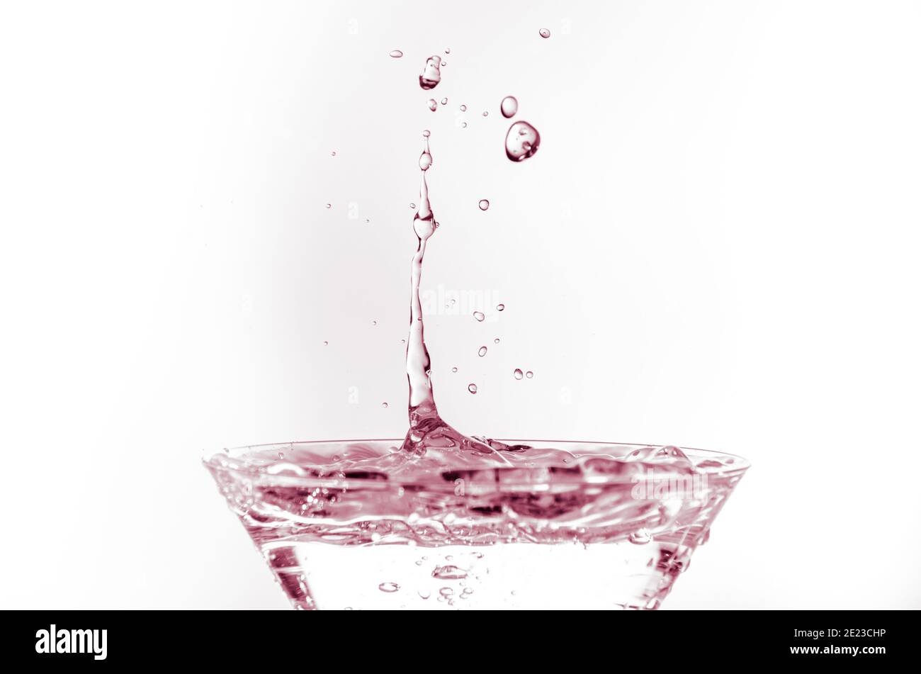 Waterdrops dropping into a glass filled with water Stock Photo - Alamy