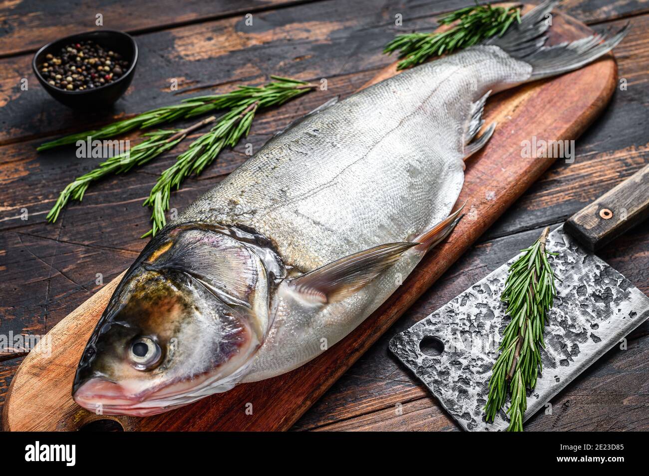 Raw fresh whole fish silver carp. Dark wooden background. Top view ...