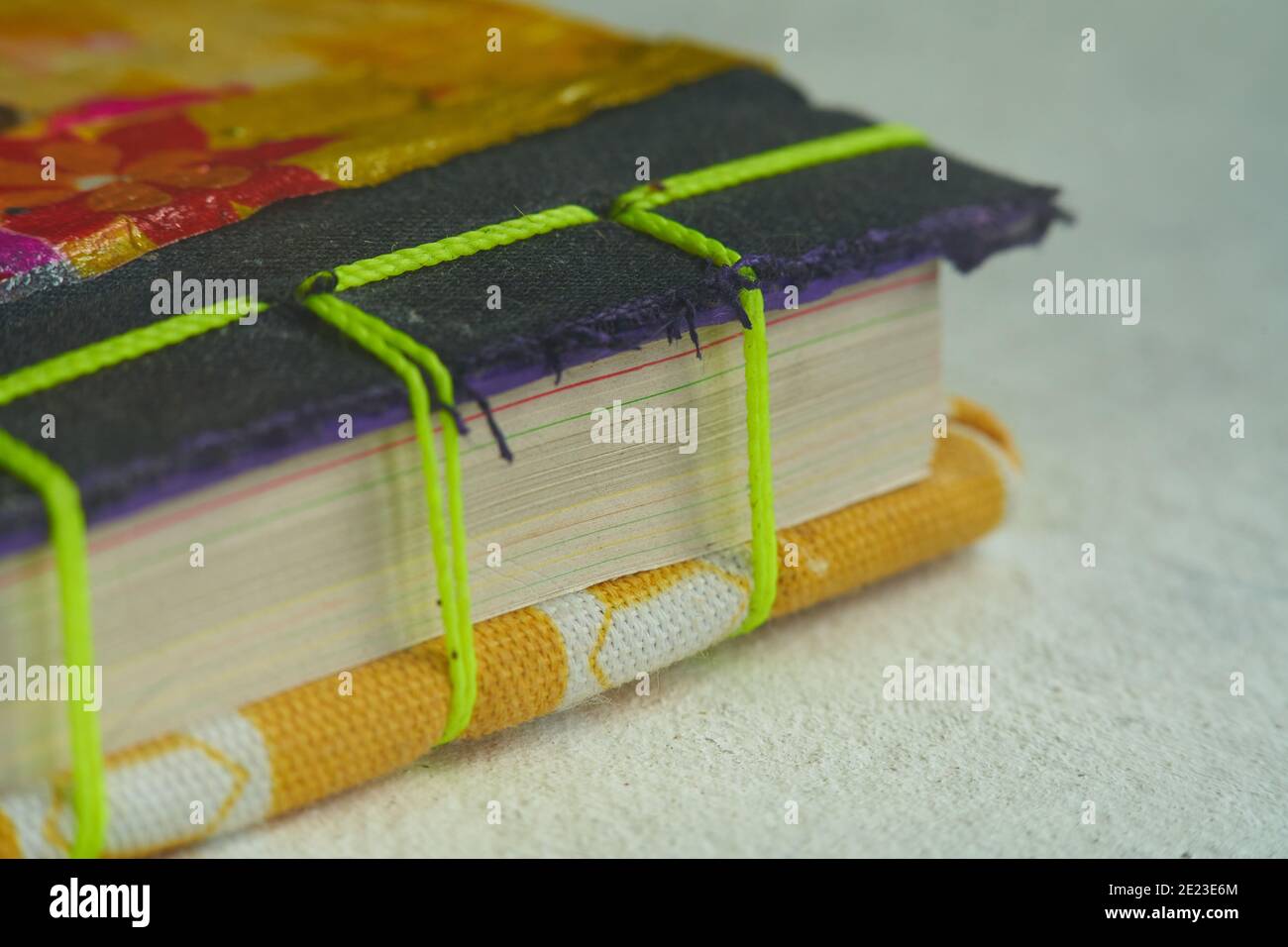 Closeup shot of folded paper sheets bound with green thread Stock Photo ...