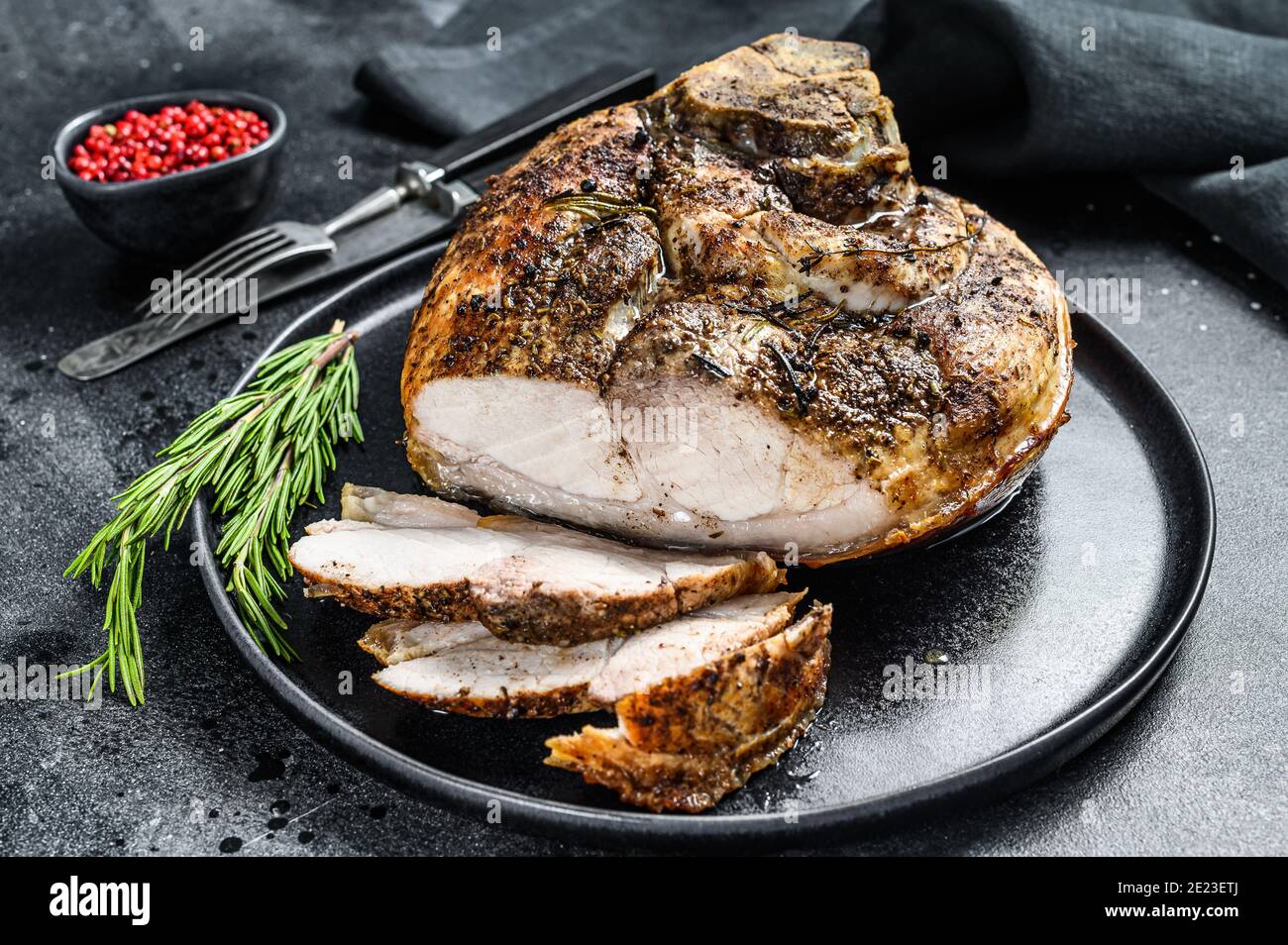 Roast sliced pork knuckle on a plate. Leg meat. Black background. Top ...