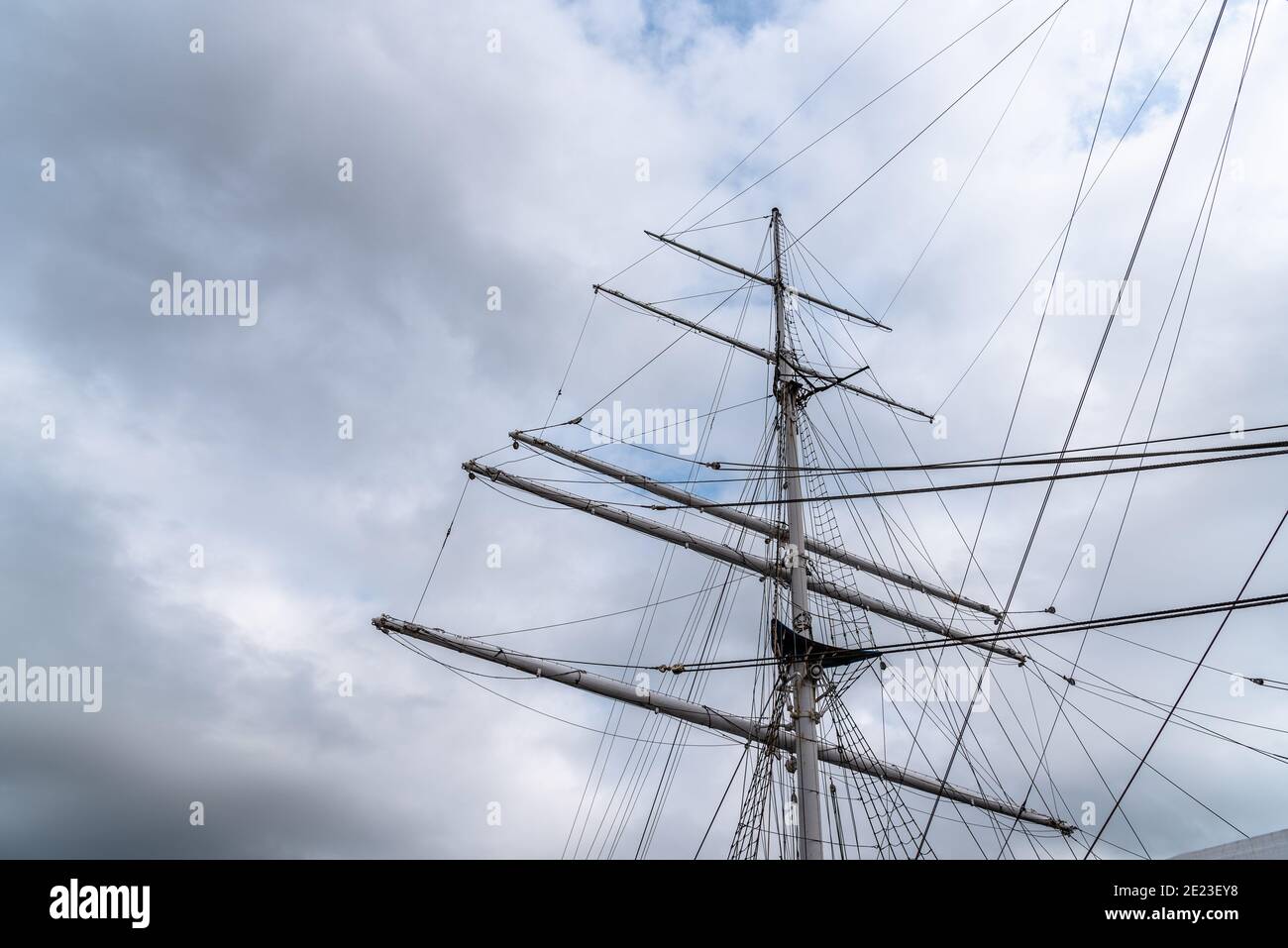 Low-angle shot of a tall ship mast and rigging on the cloudy sky ...