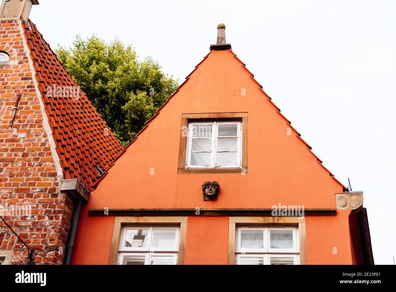 Redstone house with a red tile roof, an ornamental carved stone face on ...
