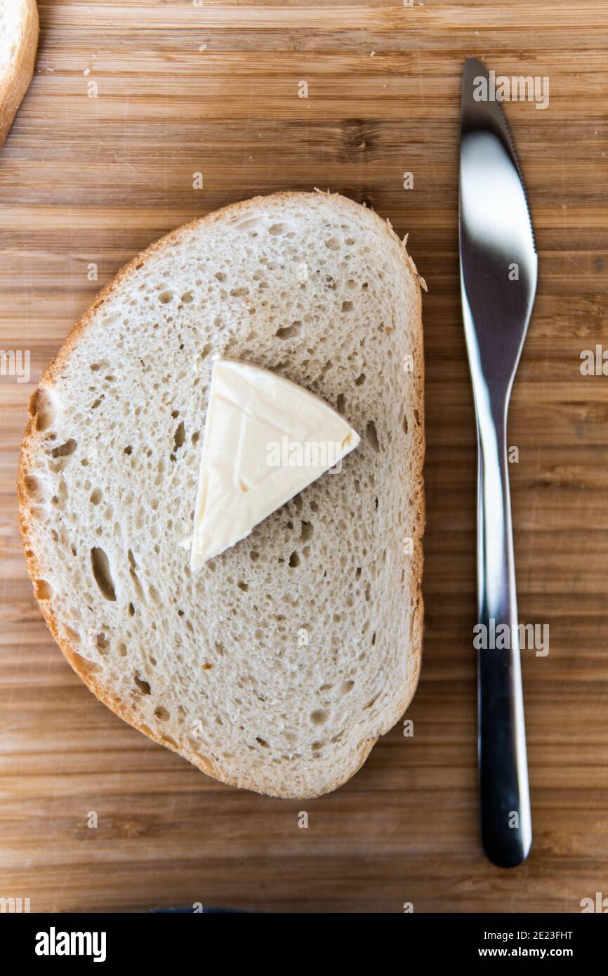 Vertical shot of a breakfast: a slice of bread with a butter on top and ...