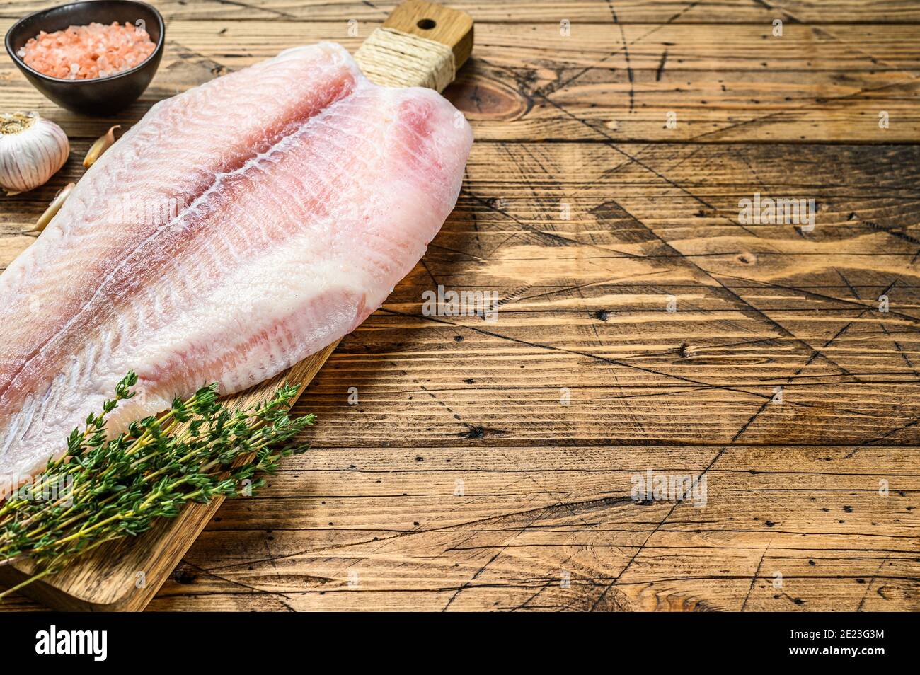 Raw fillet of white fish catfish. wooden background. Top view. Copy ...