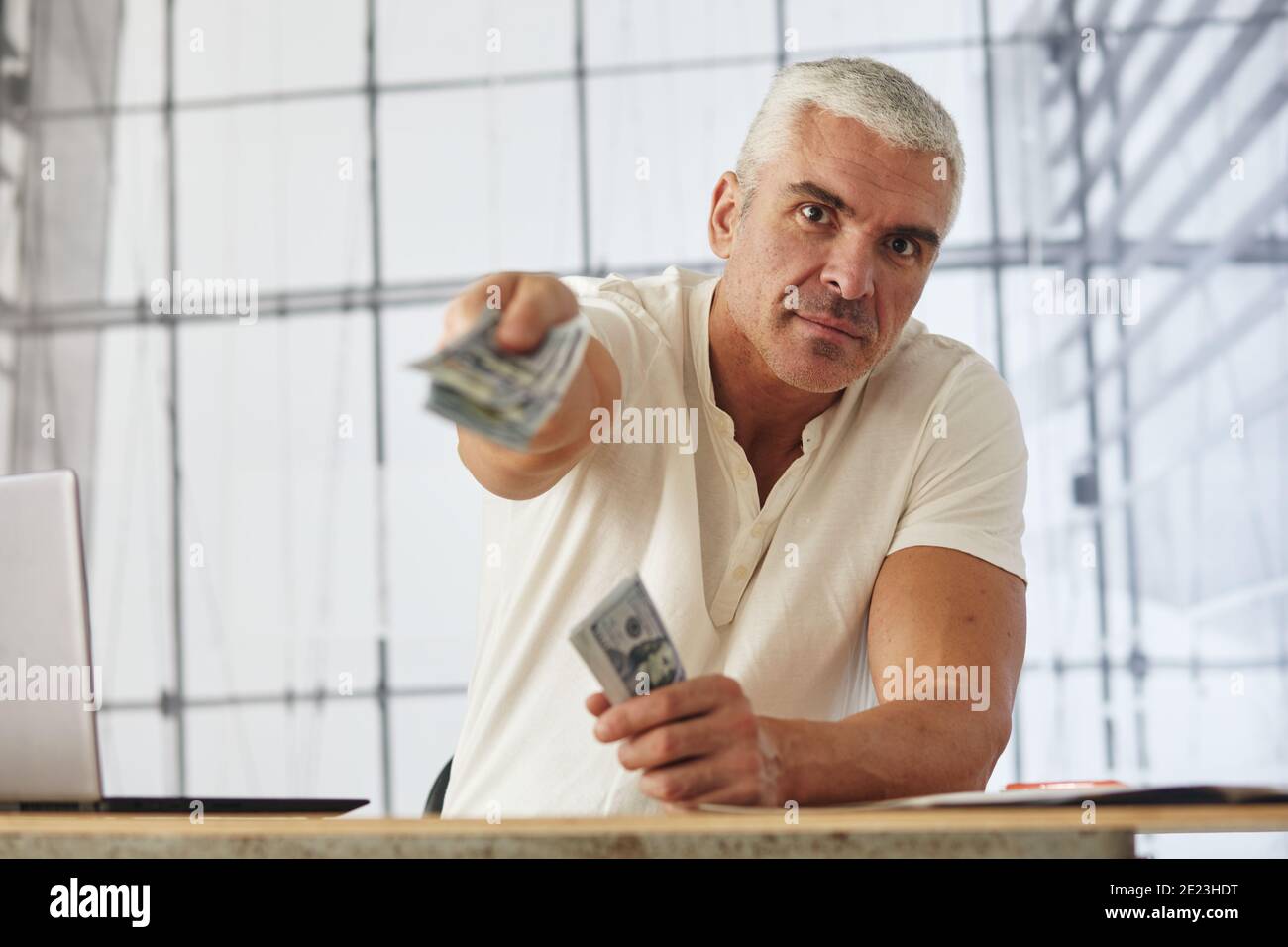Business Man Displaying a Spread of Cash over a office background Stock ...