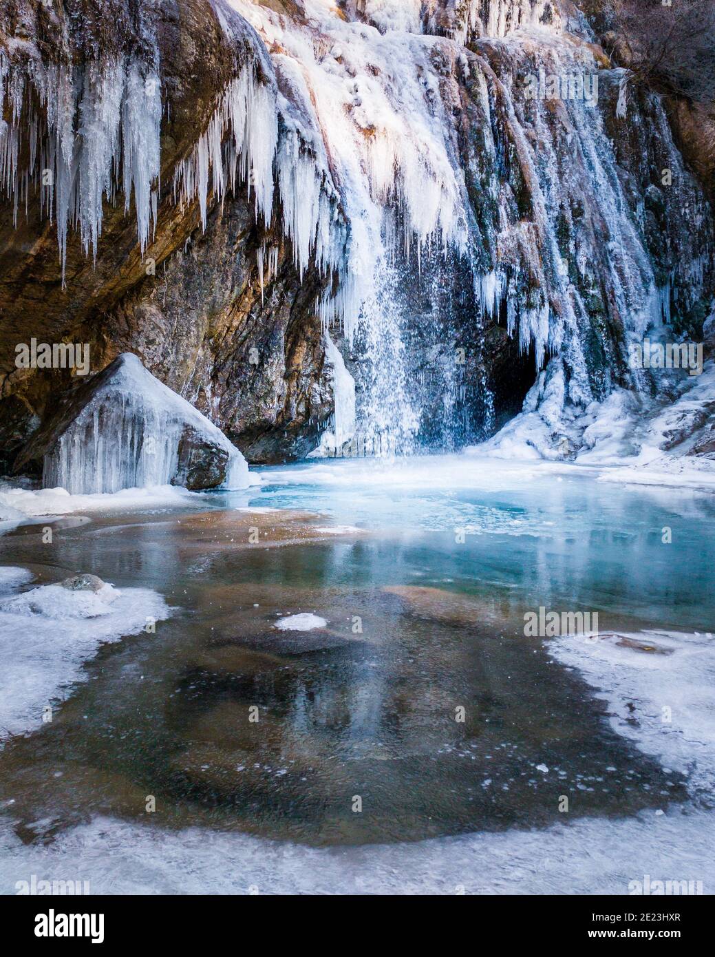 Frozen waterfall. Blue ice formation with white snow. Ice formation ...