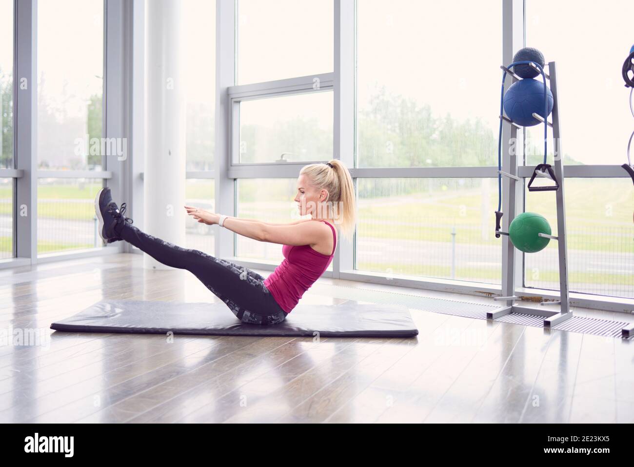 Side view of slim sportswoman doing balance exercise for abs during ...
