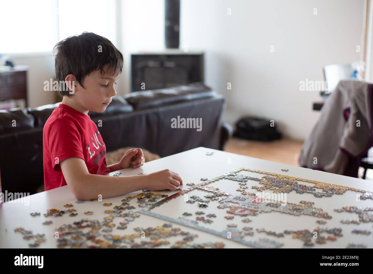 Boy putting puzzle together at kitchen counter Stock Photo - Alamy