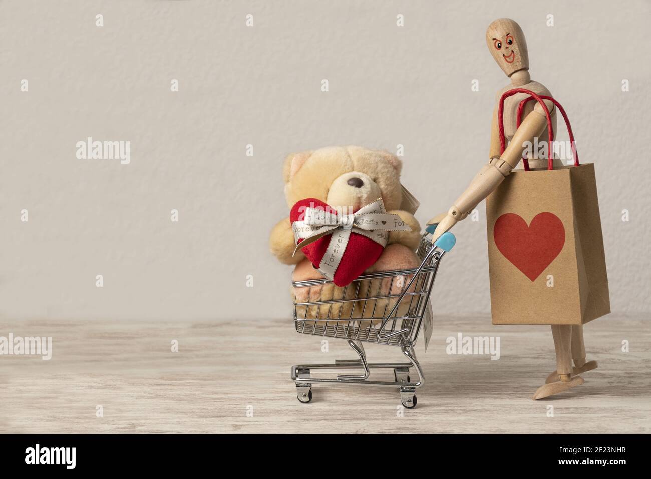 Closeup shot of a human figurine with a shopping cart and Valentines ...