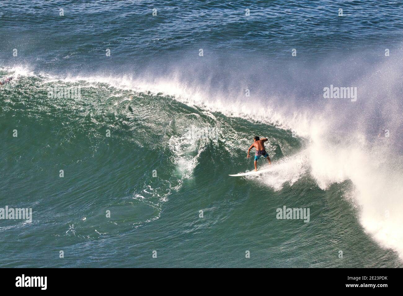 Very distant view of a big wave surfer Stock Photo - Alamy