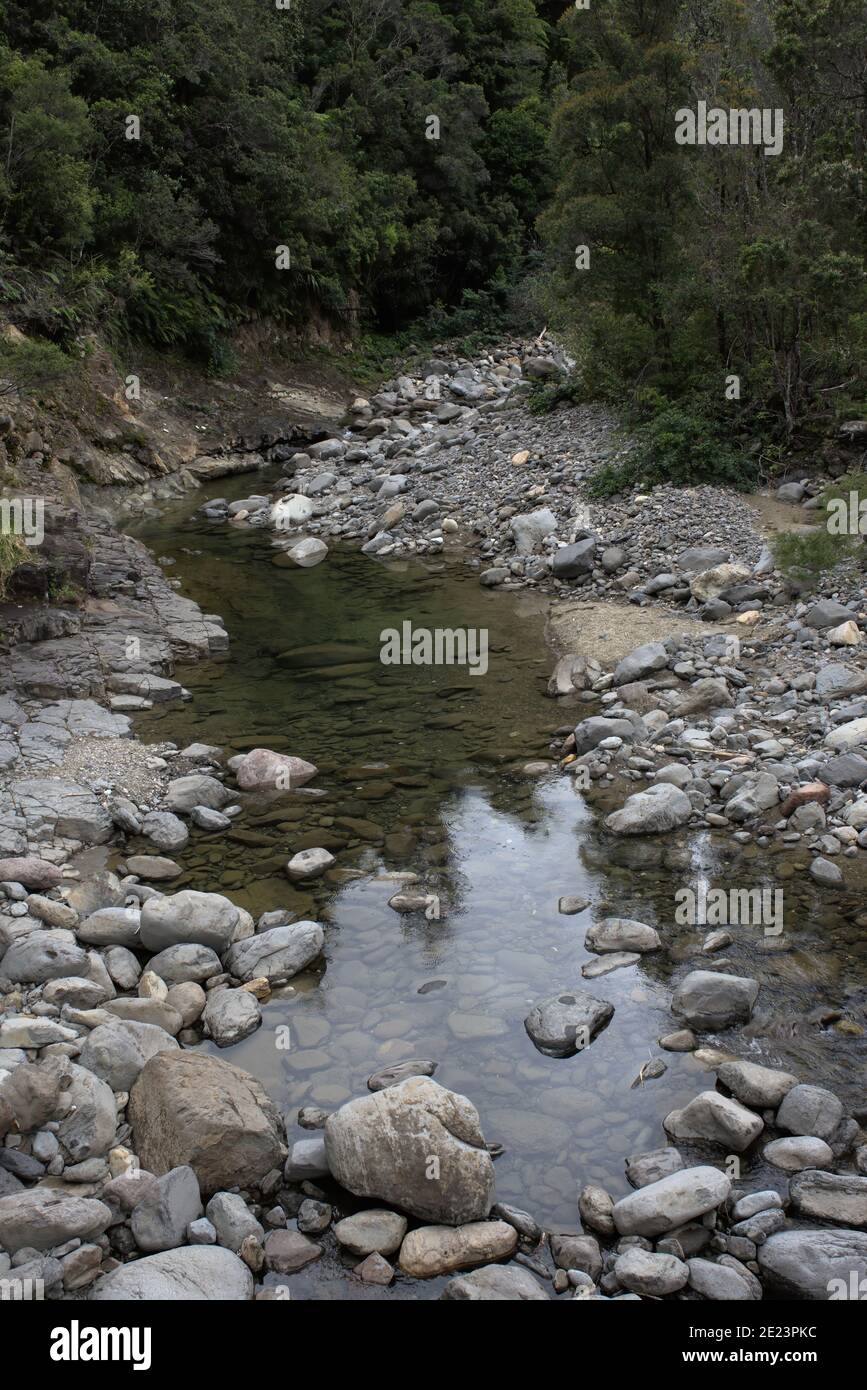 Vertical shot of a narrow water stream with rocks in a fore Stock Photo ...
