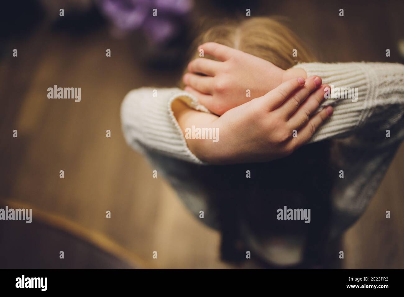 A little girl holding her hands on her neck Stock Photo - Alamy
