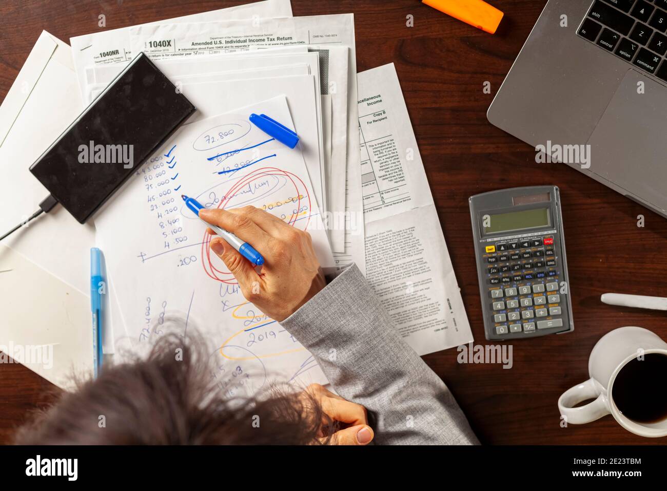 A business woman wearing formal dress is working at an office setting ...