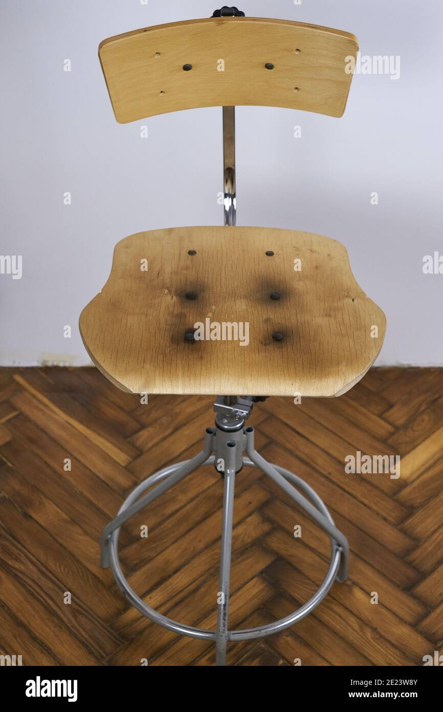Vertical shot of a wooden chair with metallic and adjustable legs in ...