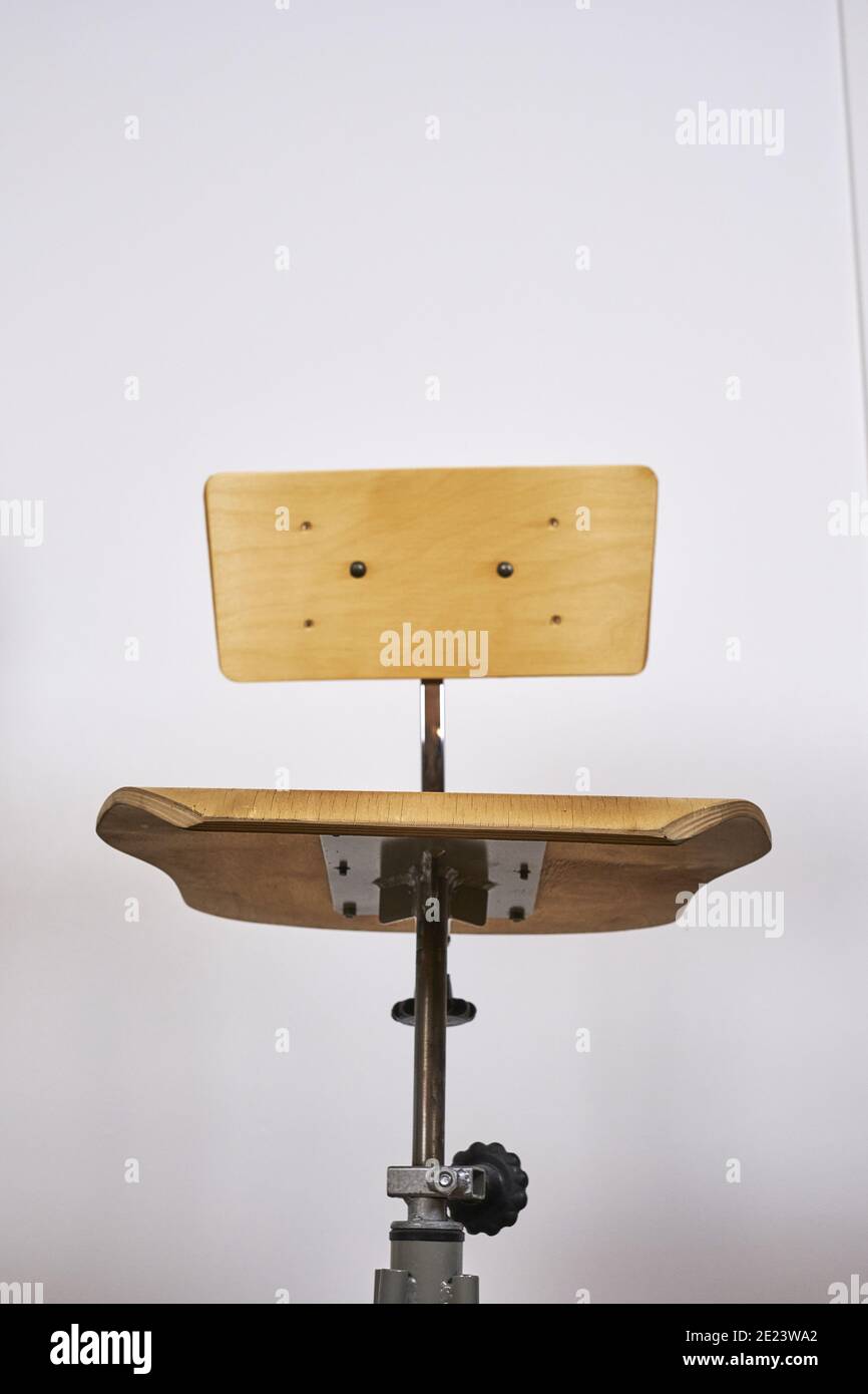 Vertical shot of a wooden chair with metallic and adjustable legs in ...