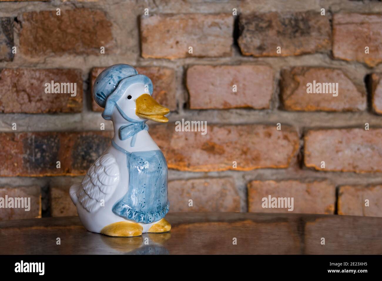 Decorative ceramic duck statue on a brick wall background Stock Photo ...
