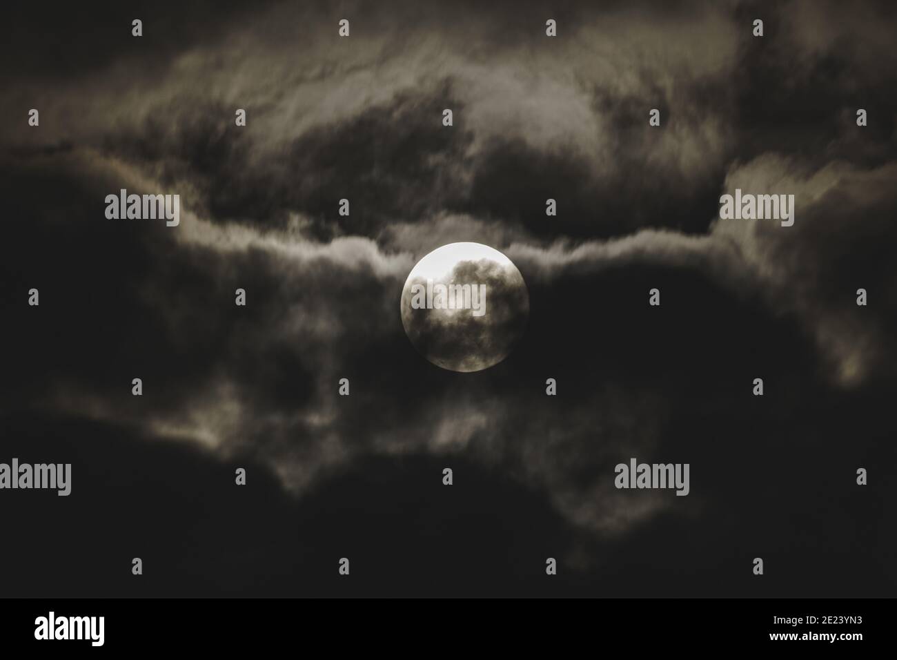 Full moon behind the dark clouds in the sky Stock Photo - Alamy