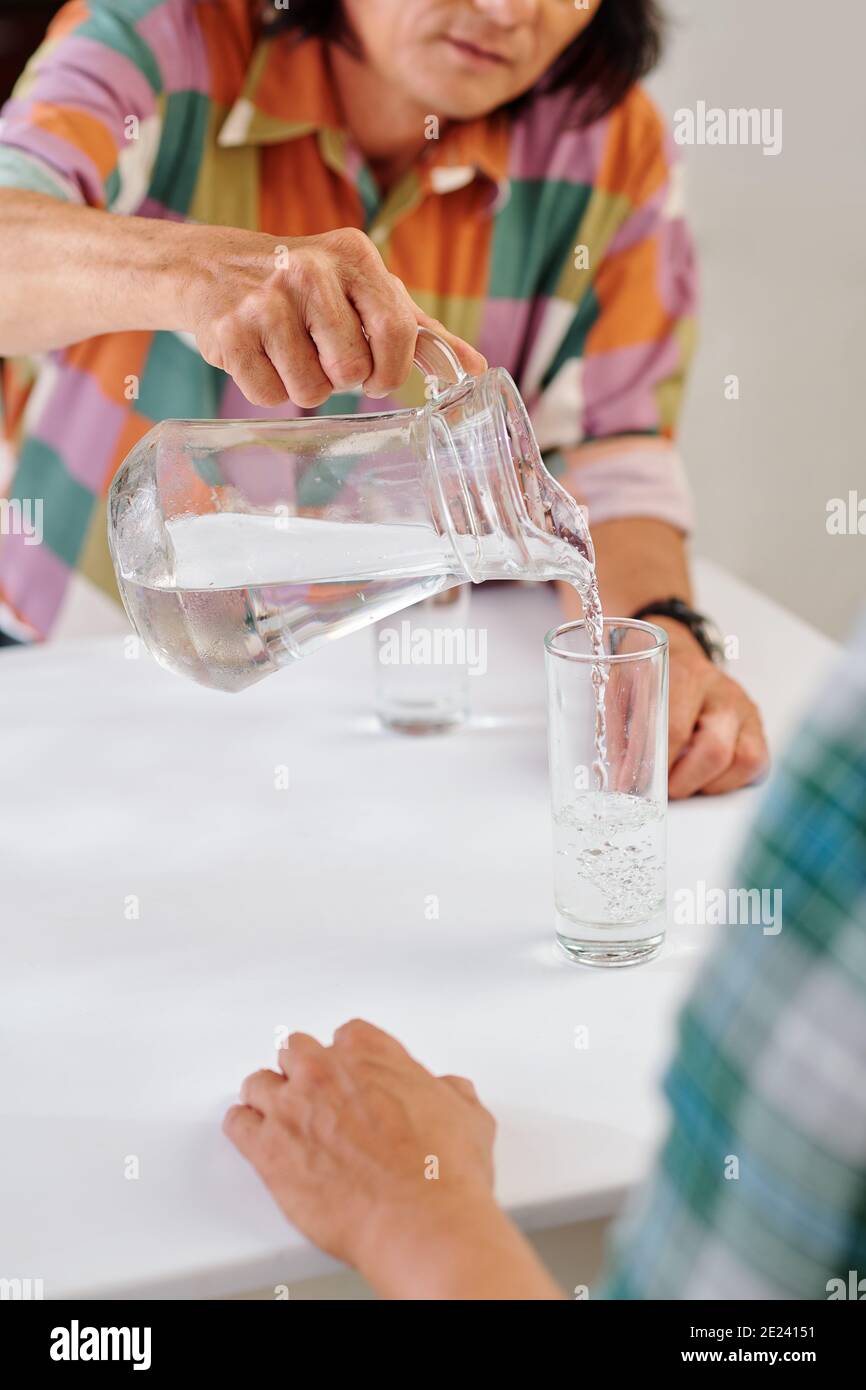 Pouring glass of water for friend Stock Photo - Alamy