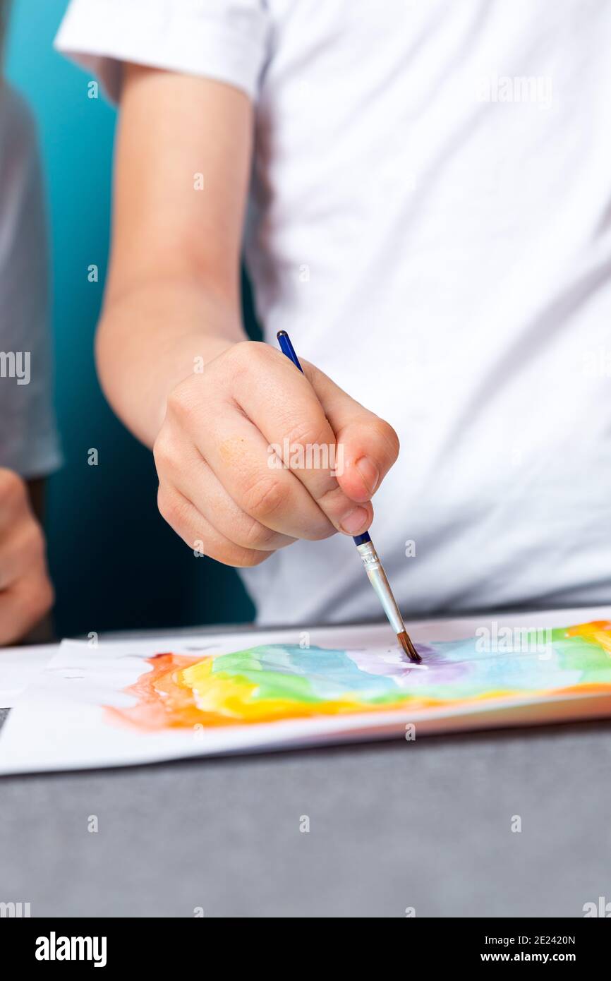 Children's creativity. Close up of the boy paint watercolor homework ...