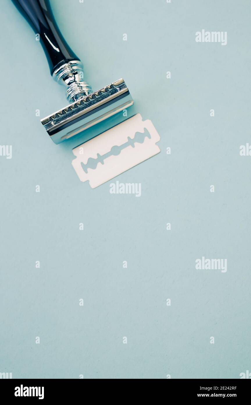 Vertical shoy of mechanical razor and blade isolated on blue background ...