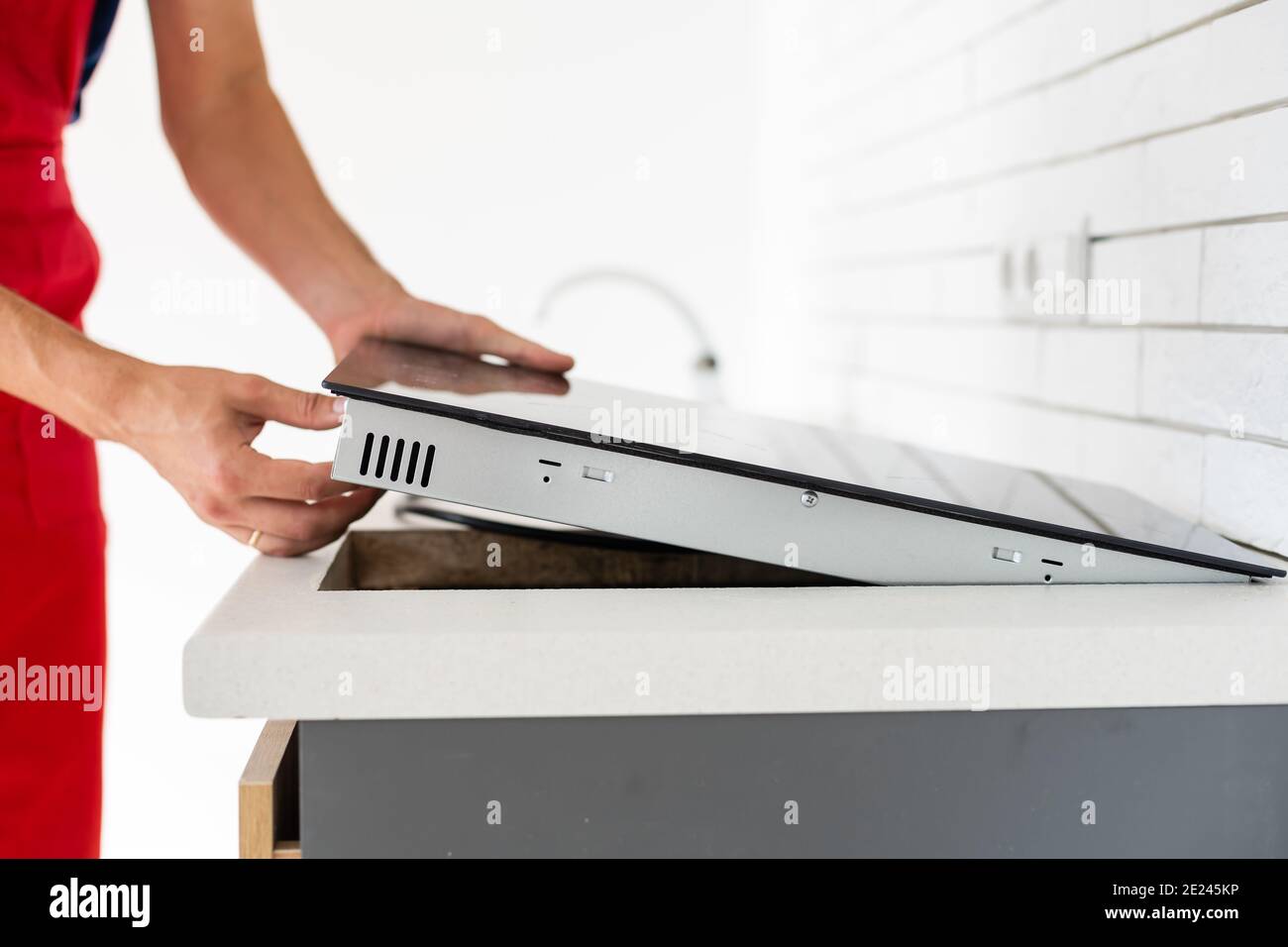 Installation of induction stove or cooktop by a master Stock Photo - Alamy