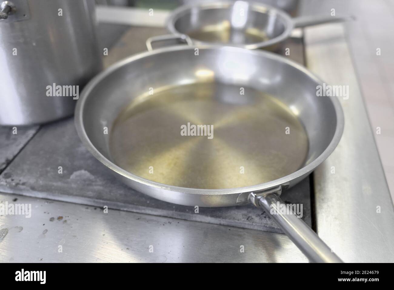 Gray stylish aluminum cookware on the stove in the dining room. A round ...