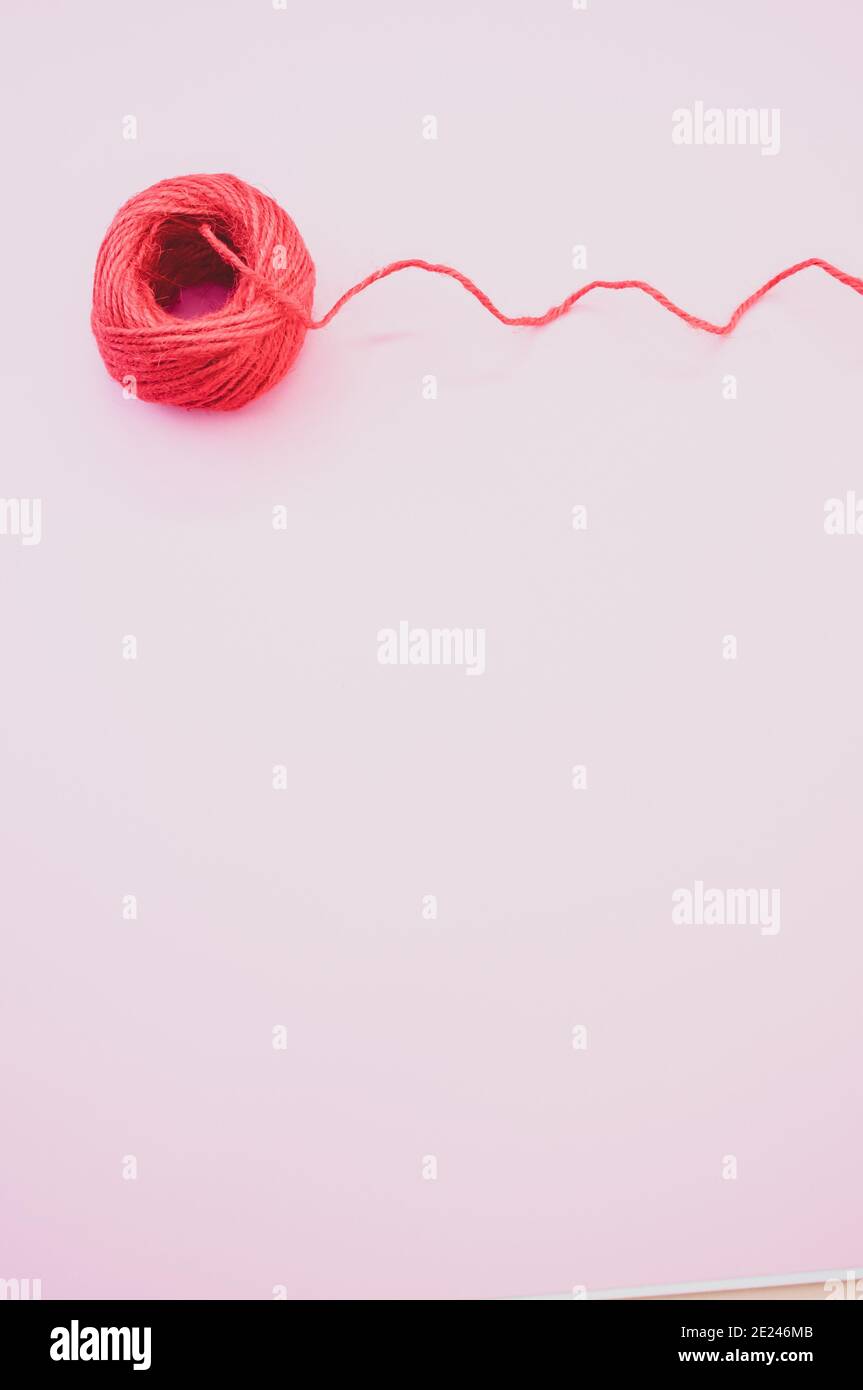 Vertical shot of bright red woolen yarn on a purple background Stock ...