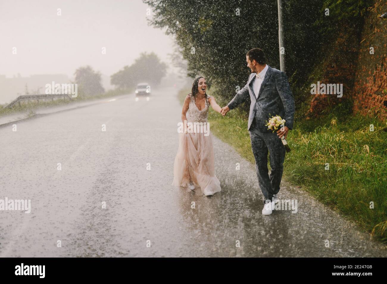Just married couple holding hands and walking on rain. Walking in wet ...