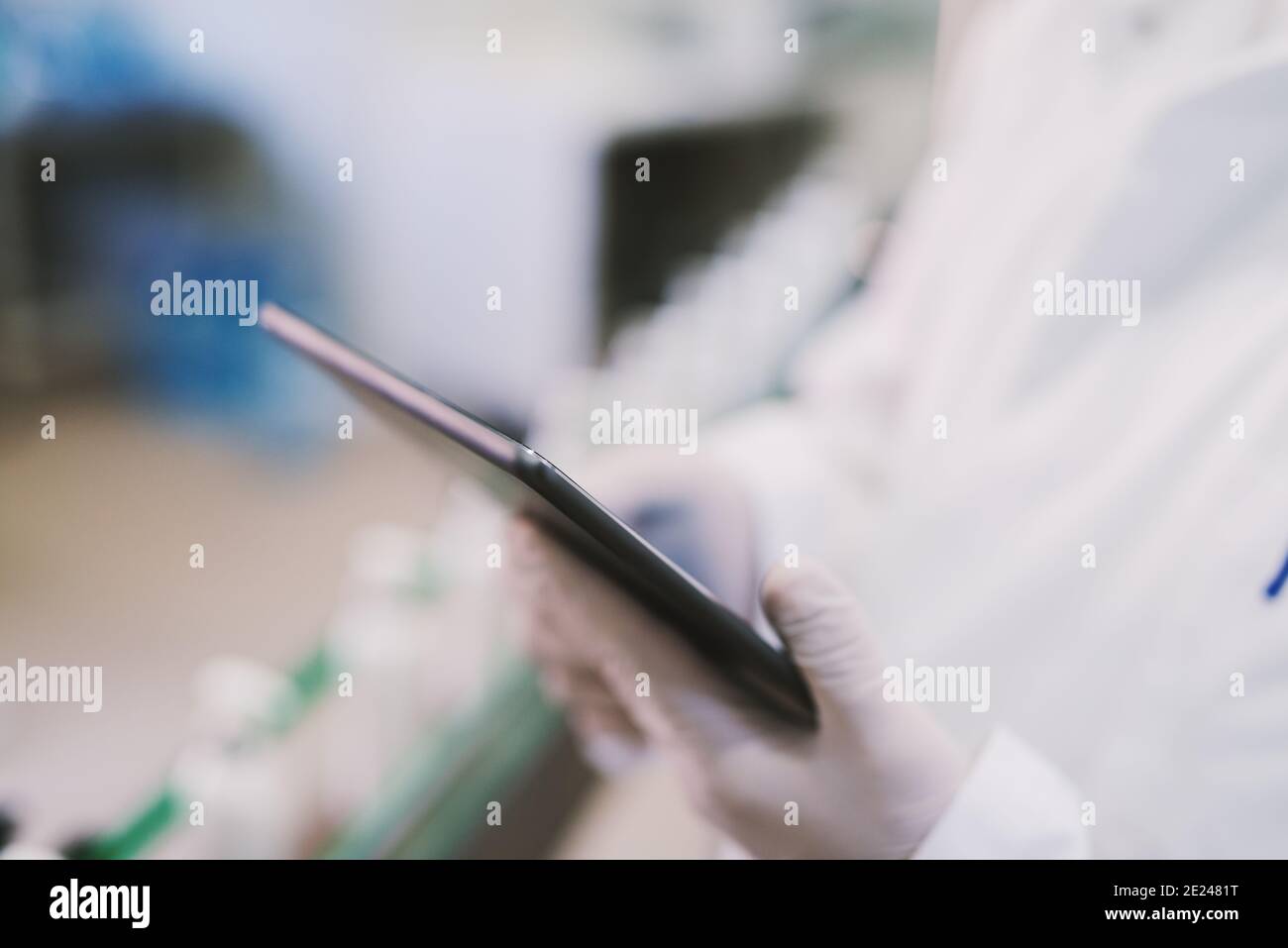 Close up of tablet in males hands. Man in sterile clothes using tablet ...