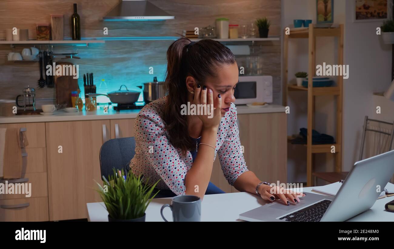 Overworked woman falling asleep in home kitchen late at night. Busy ...