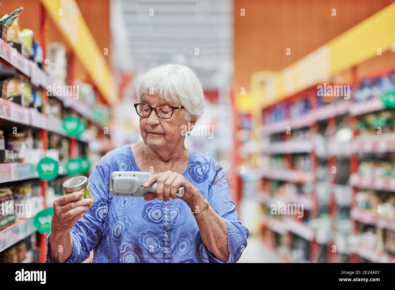 Senior woman using barcode reader in shop Stock Photo - Alamy