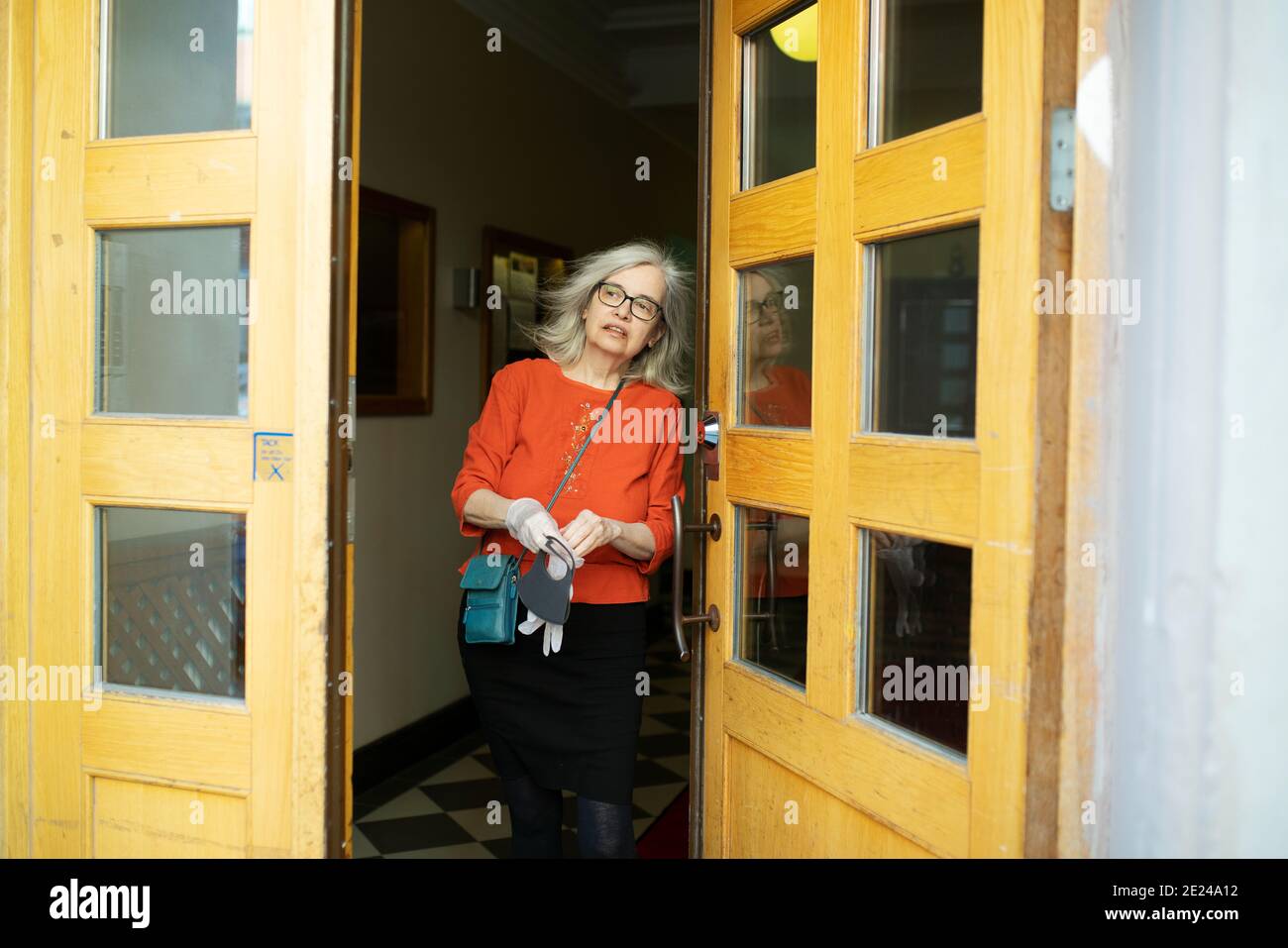 Woman leaving house Stock Photo - Alamy