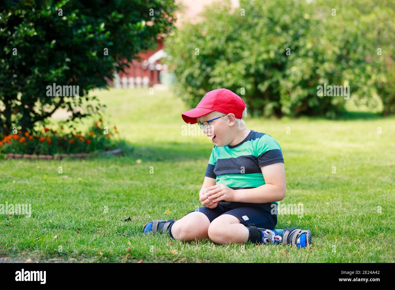 Happy boy sitting in garden Stock Photo - Alamy