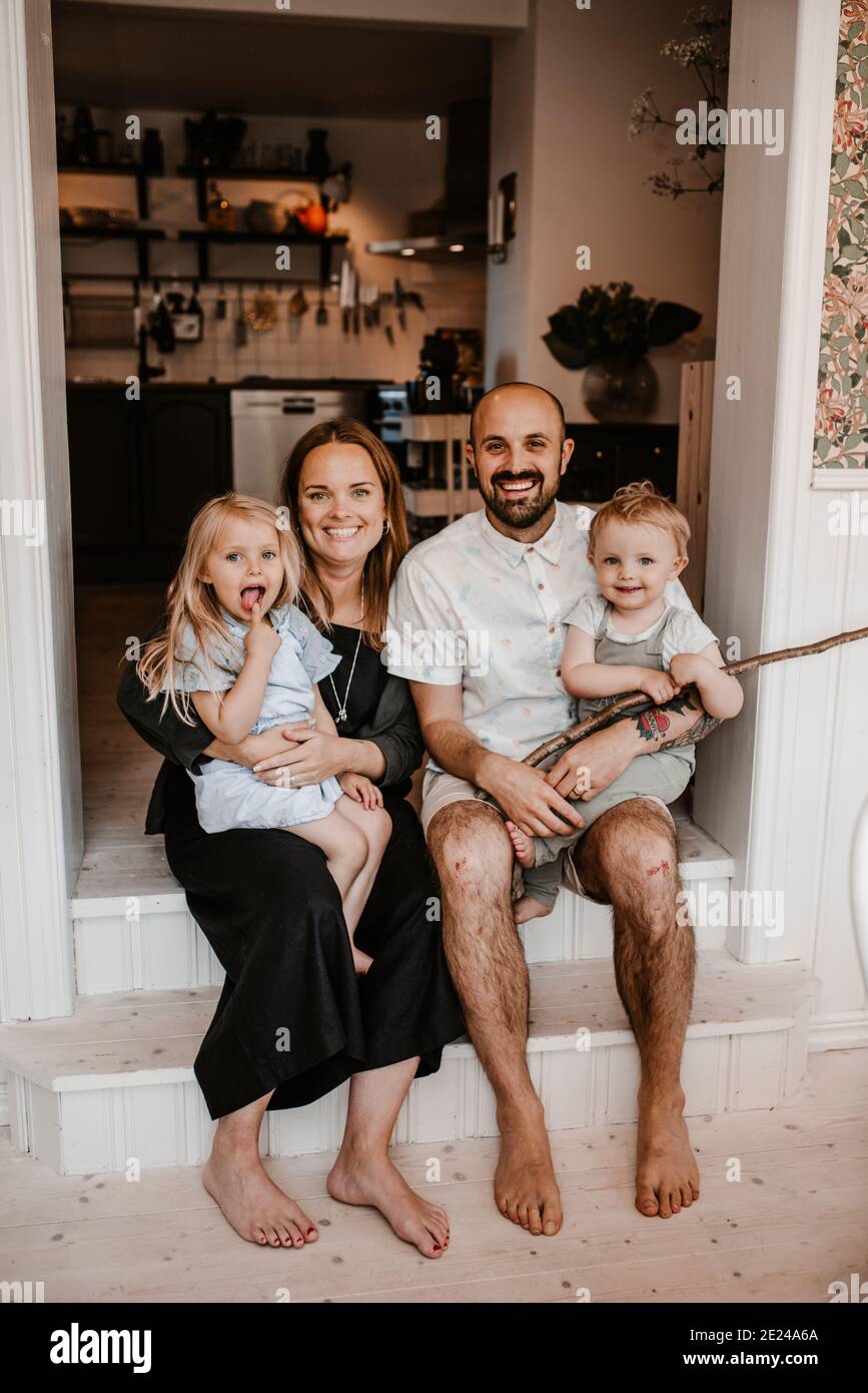 Smiling parents with kids looking at camera Stock Photo - Alamy