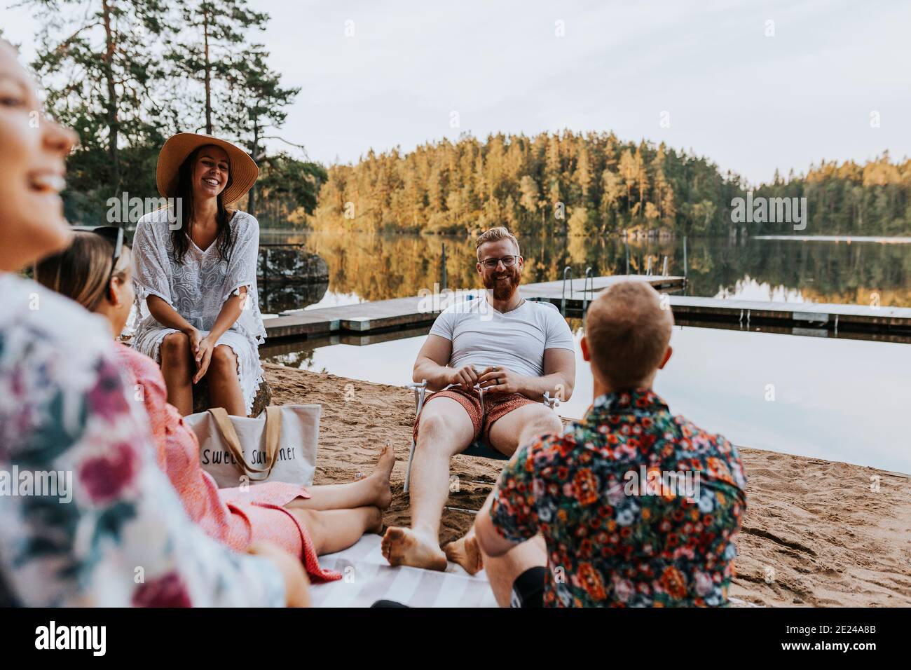 Happy friends relaxing at lake Stock Photo - Alamy