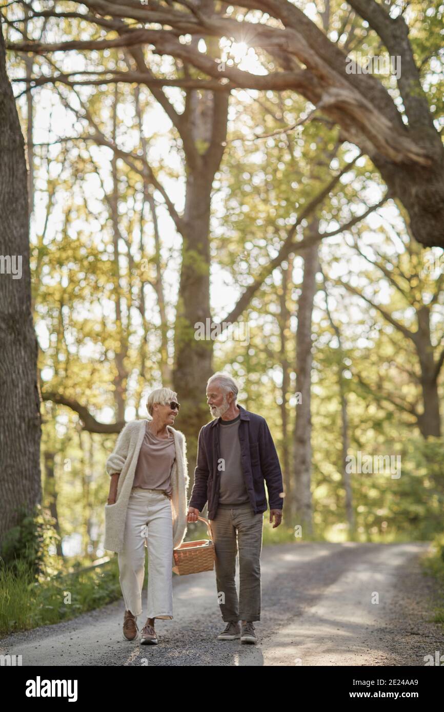 Couple carrying picnic basket together Stock Photo - Alamy