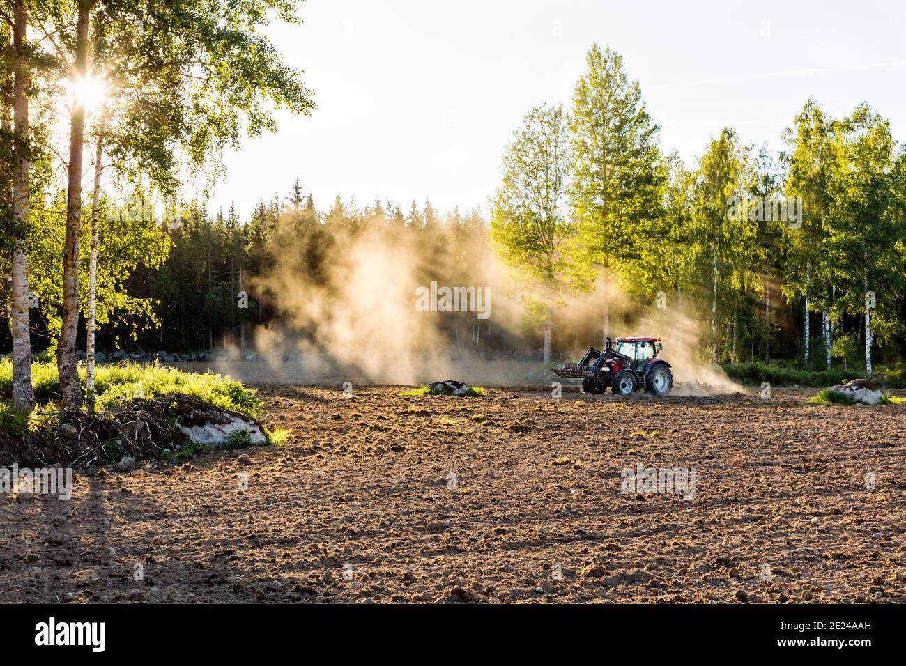 Tractor harrowing field Stock Photo - Alamy