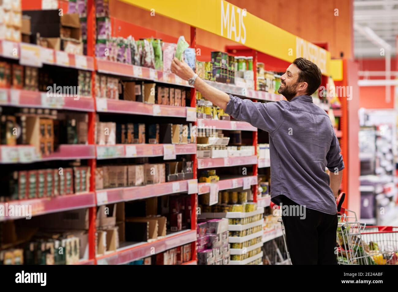 Man doing shopping in supermarket Stock Photo - Alamy