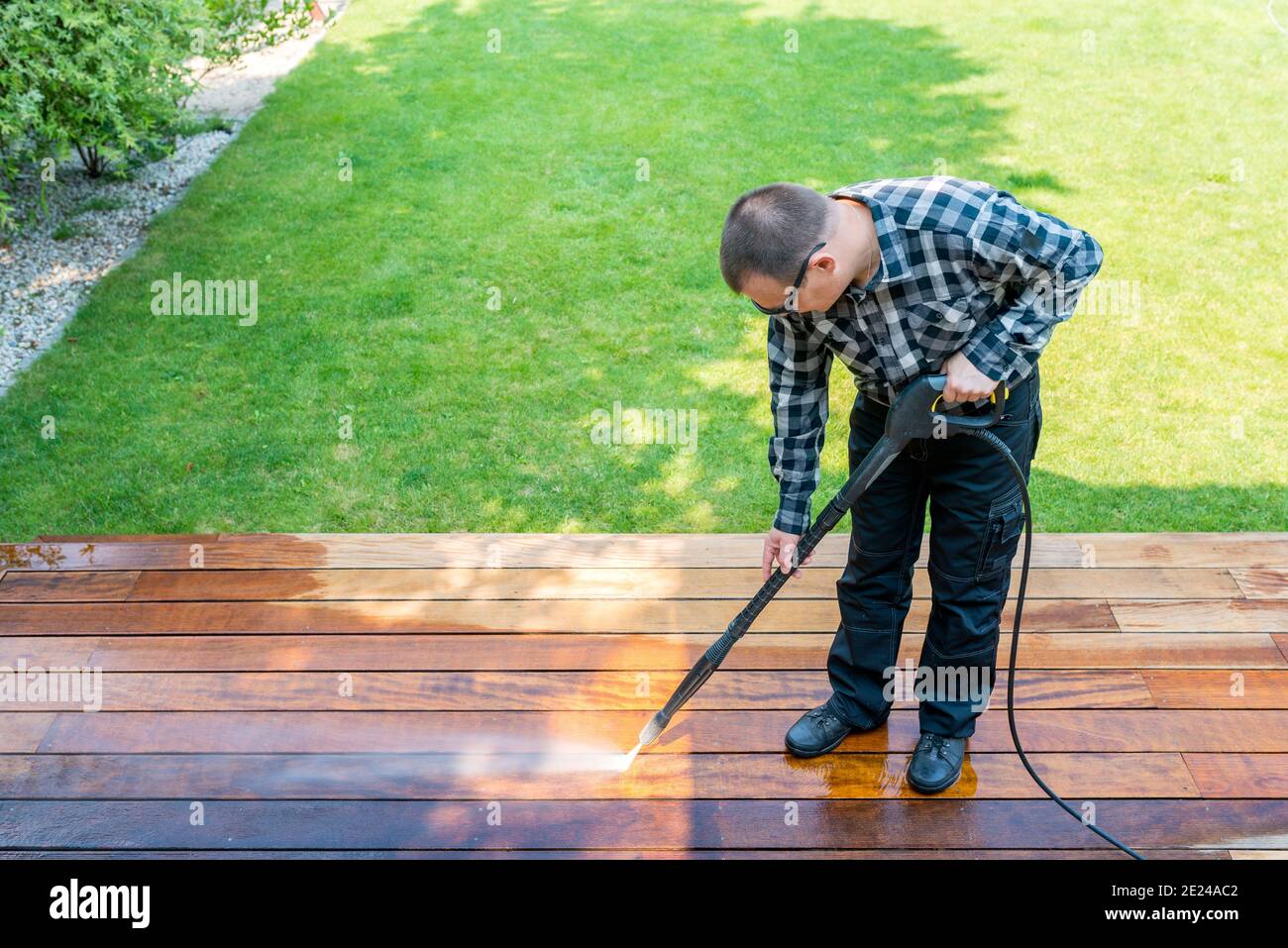 power washing - man cleaning terrace with a power washer - high water ...