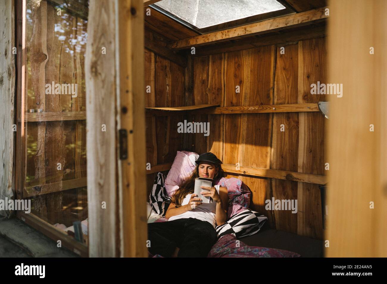 Woman in hut reading book Stock Photo - Alamy