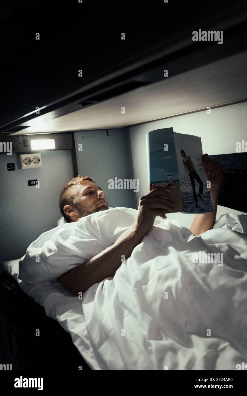 Man reading in ferry cabin bed Stock Photo - Alamy