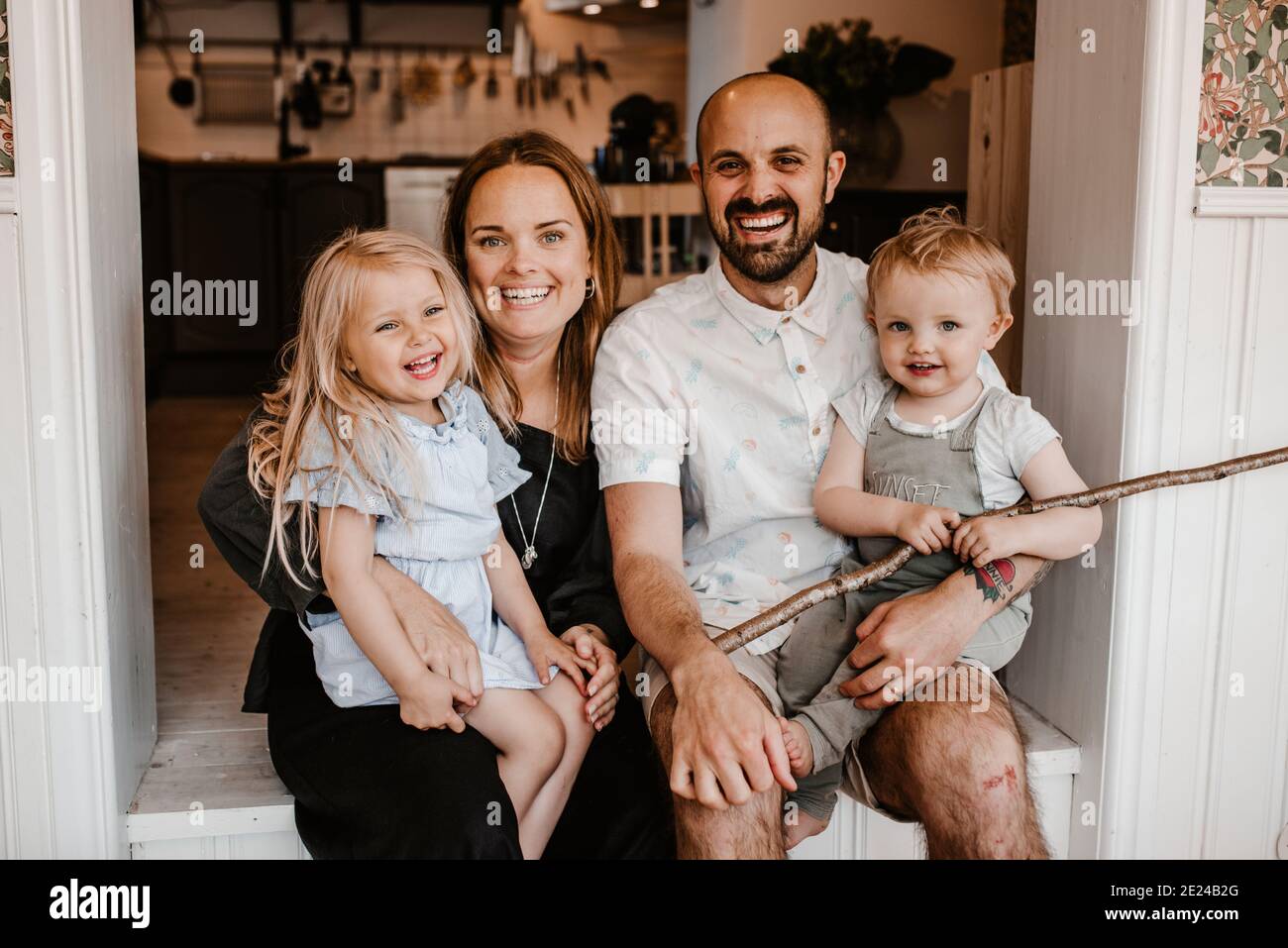 Smiling parents with kids looking at camera Stock Photo - Alamy