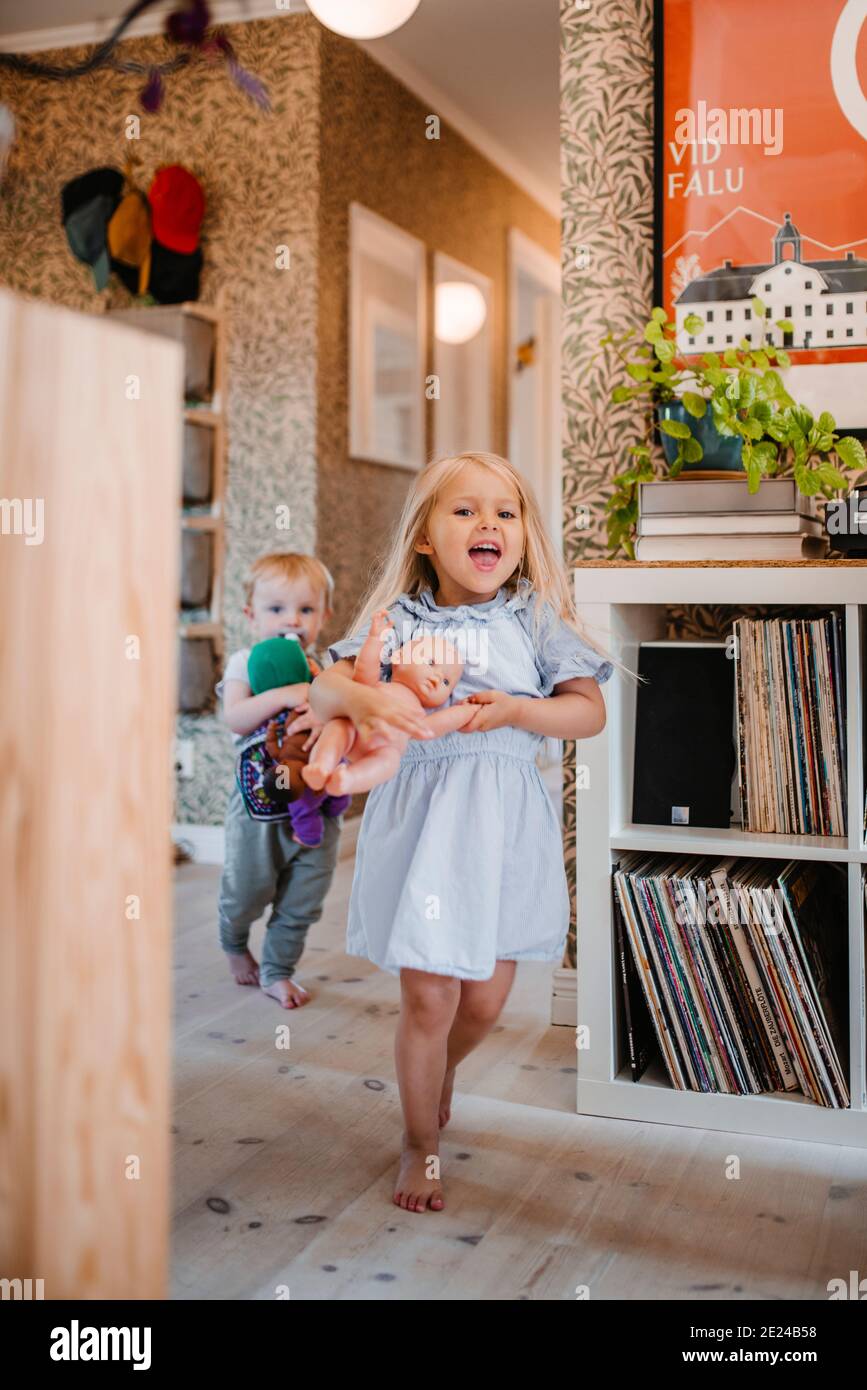 Happy girl running with doll Stock Photo - Alamy