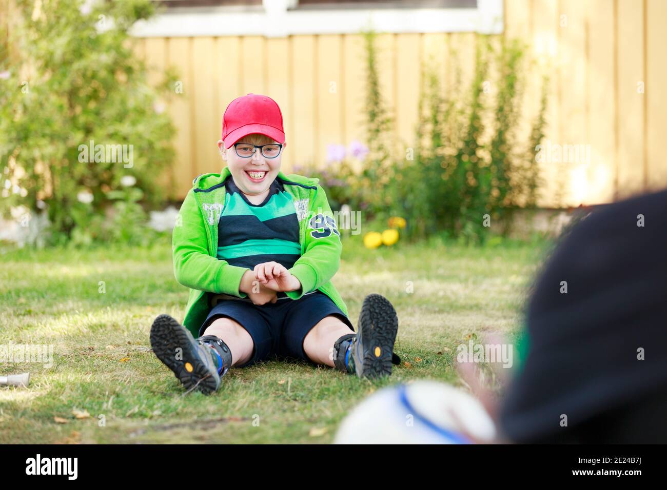 Happy boy sitting in garden Stock Photo - Alamy