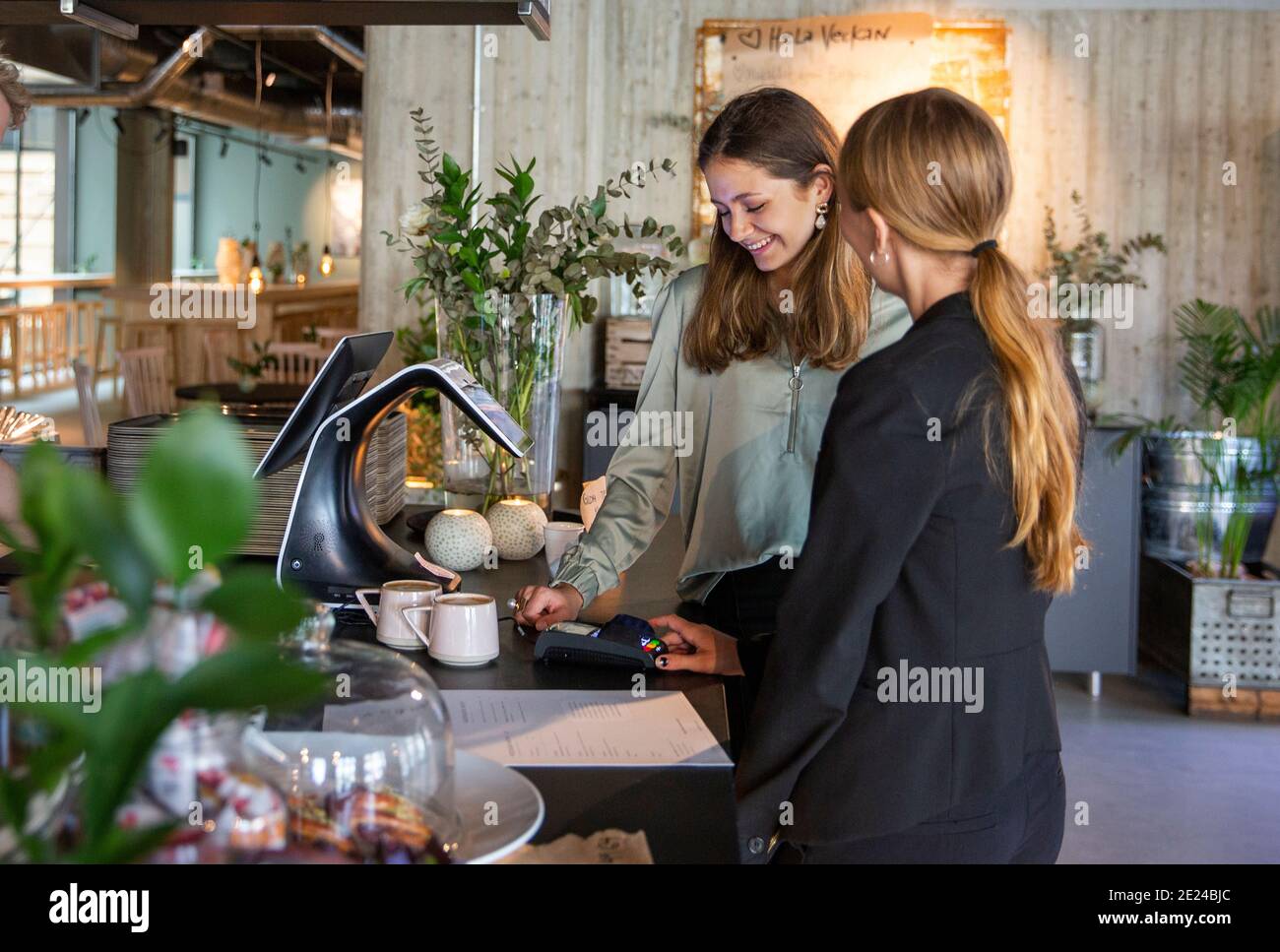 Women paying in cafe Stock Photo - Alamy